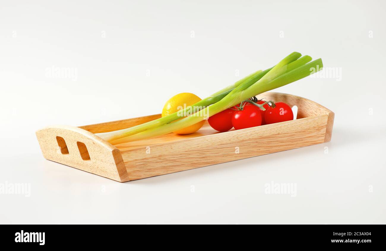 Spring onion, tomatoes and lemon on wooden serving tray Stock Photo - Alamy