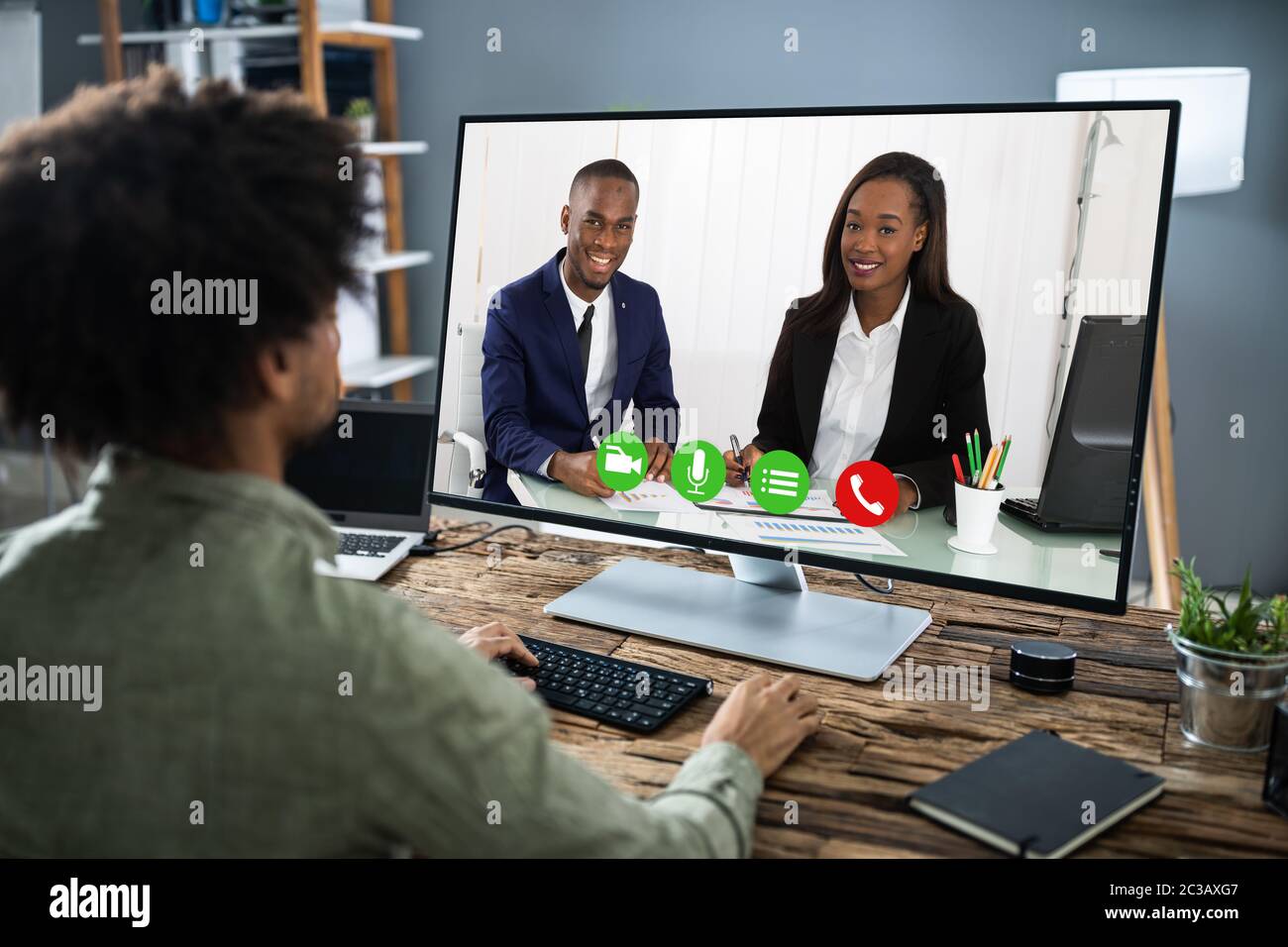 Businessman Sitting At A Desk Watching An Online Presentation On The ...