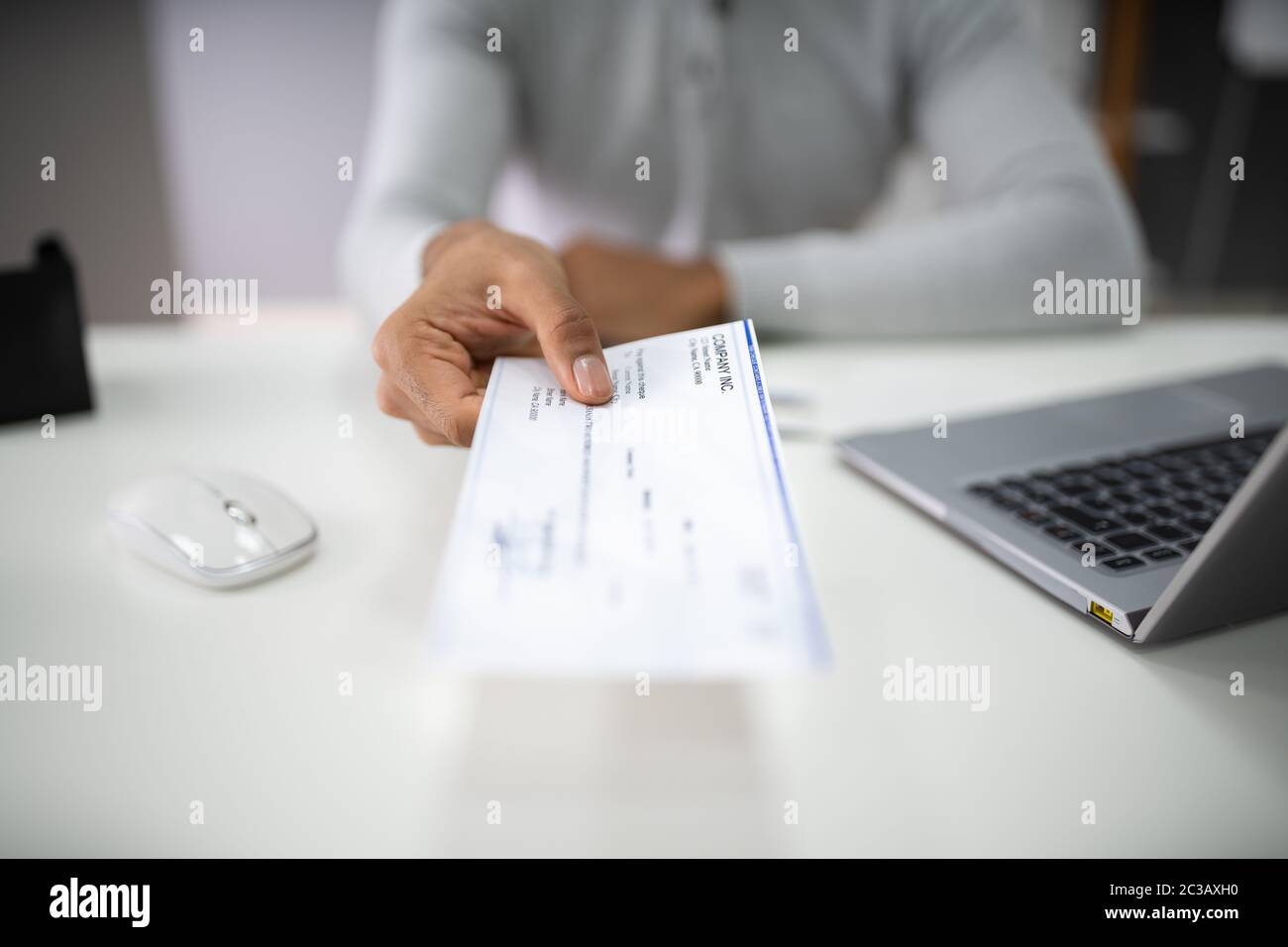 Close-up Of A Human Hand Giving Cheque On Desk Stock Photo - Alamy