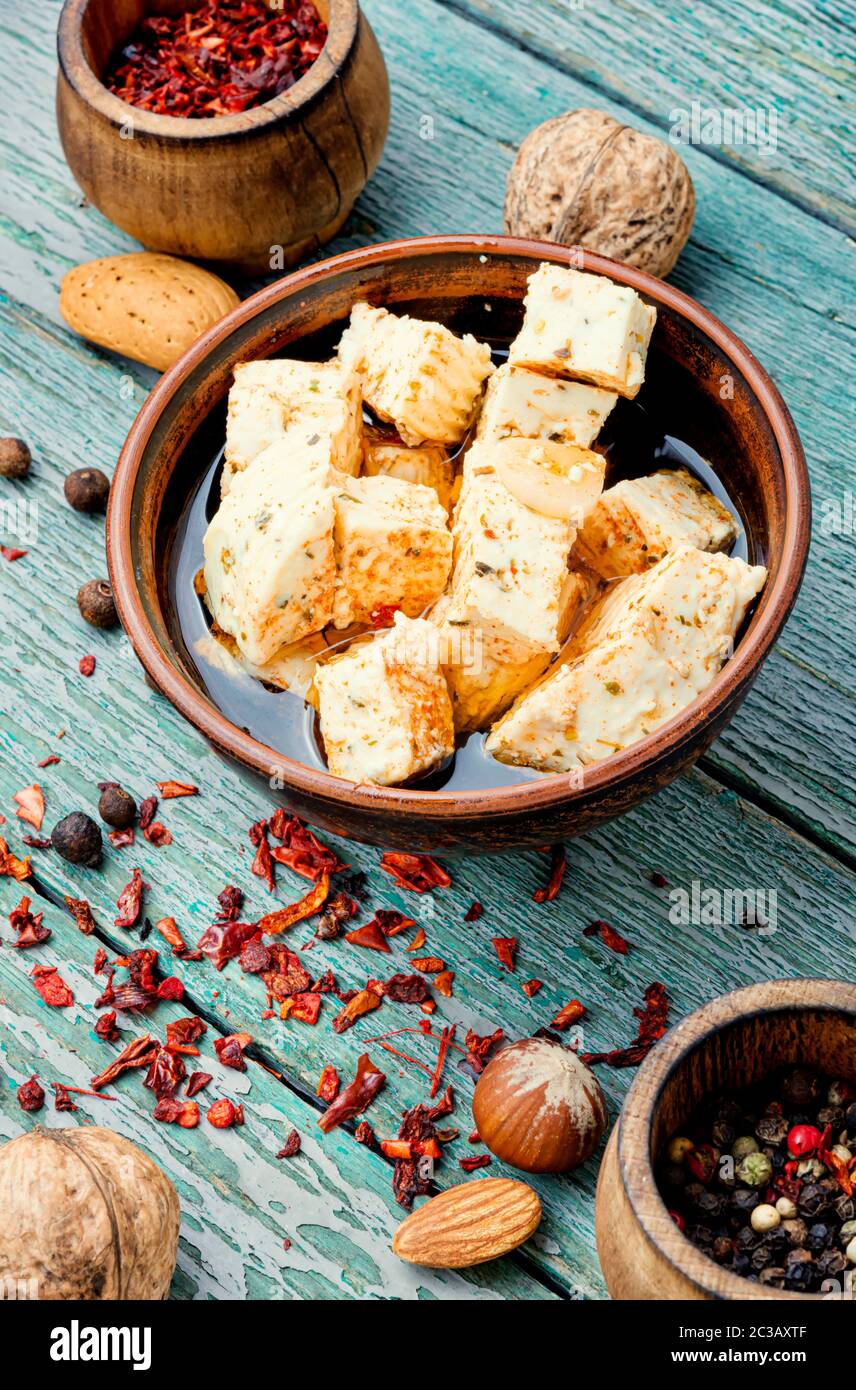 Feta cheese with herbs and garlic on old wooden background Stock Photo ...