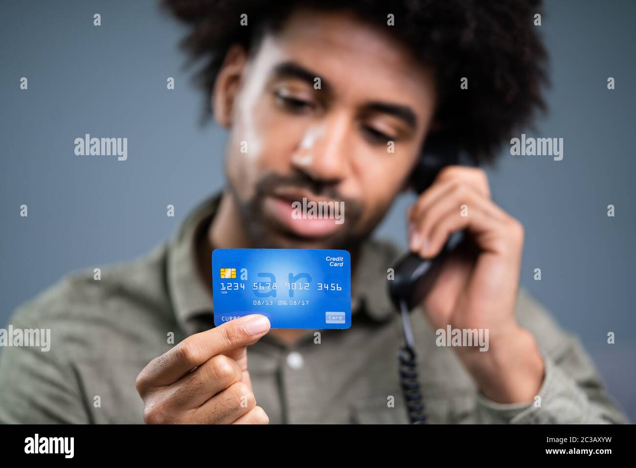 Close-up Of A an With Credit Card Using Landline Phone Stock Photo - Alamy