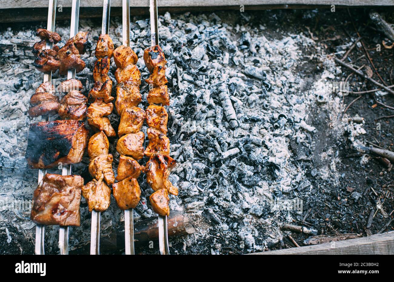 Chicken skewers on skewers on fire. Cooking meat outdoors in the open ...