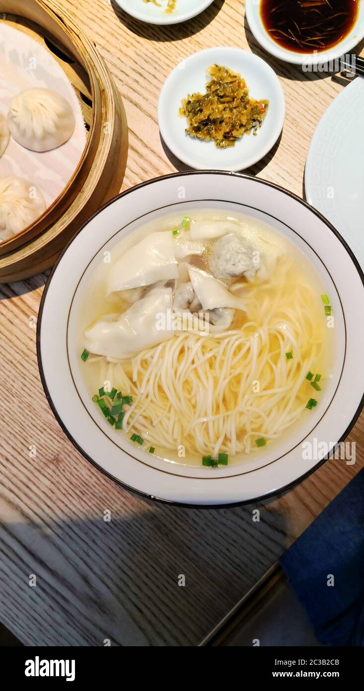 Wontons in a broth with noodles. Chinese cuisine Stock Photo - Alamy