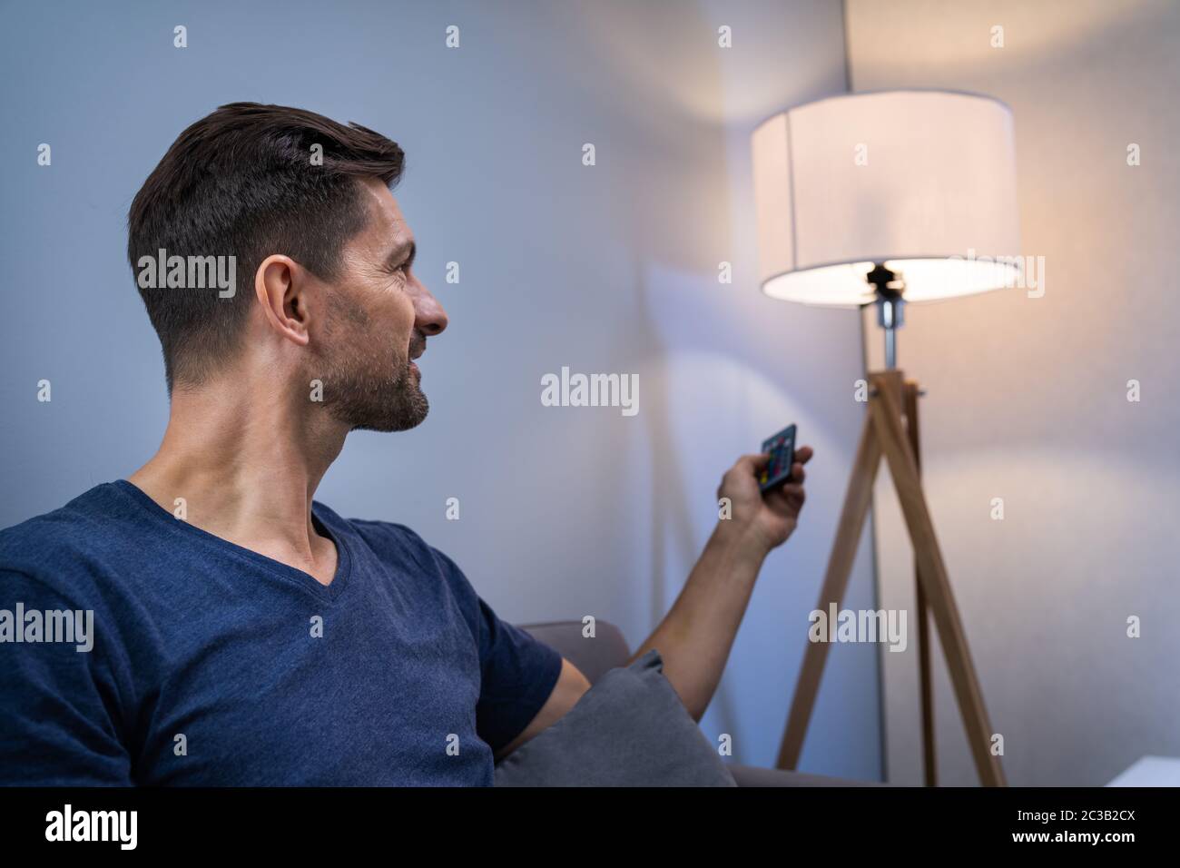 Person Controlling Smart Light With Remote Control Stock Photo - Alamy