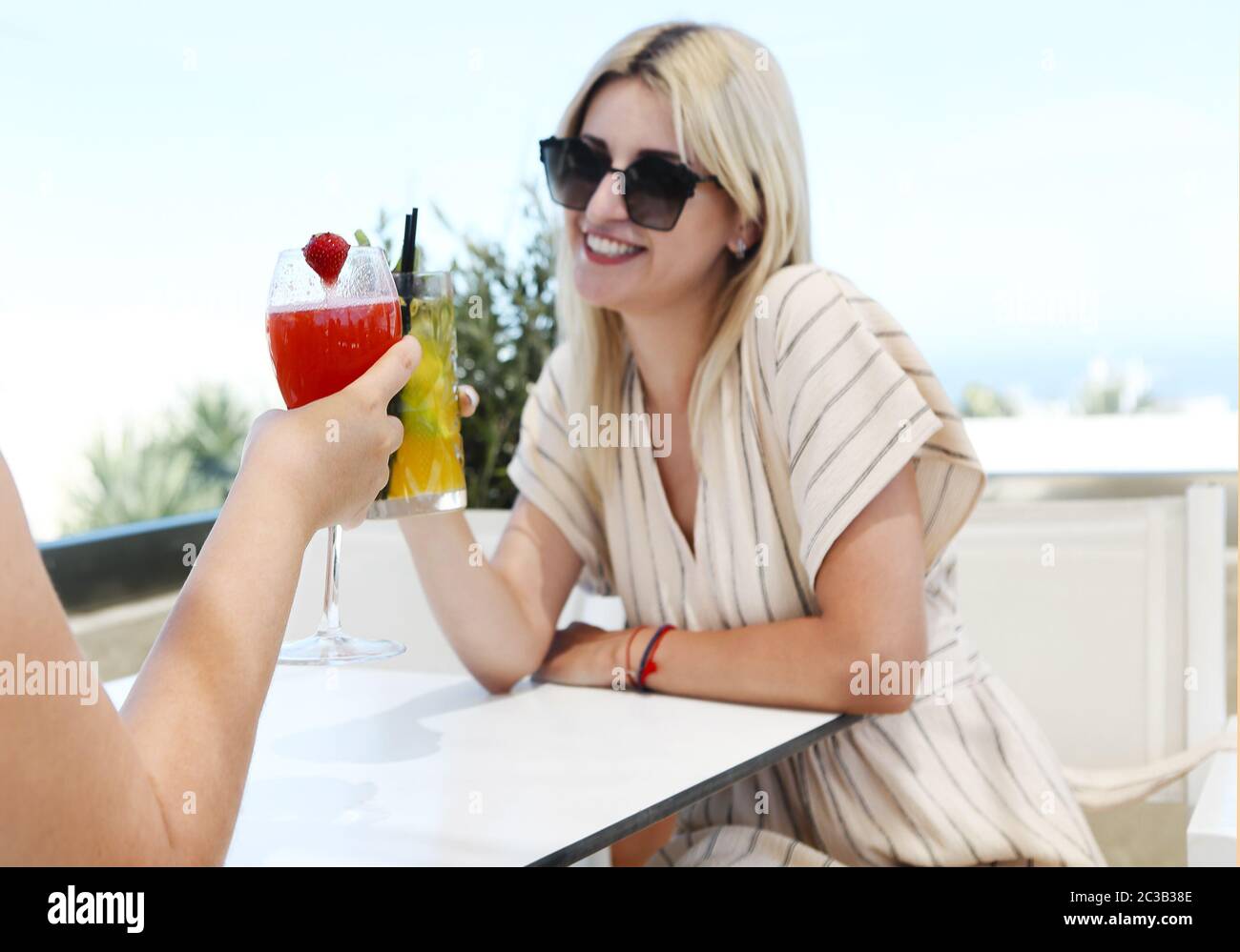 Happy women with cocktails proposing toast Stock Photo - Alamy