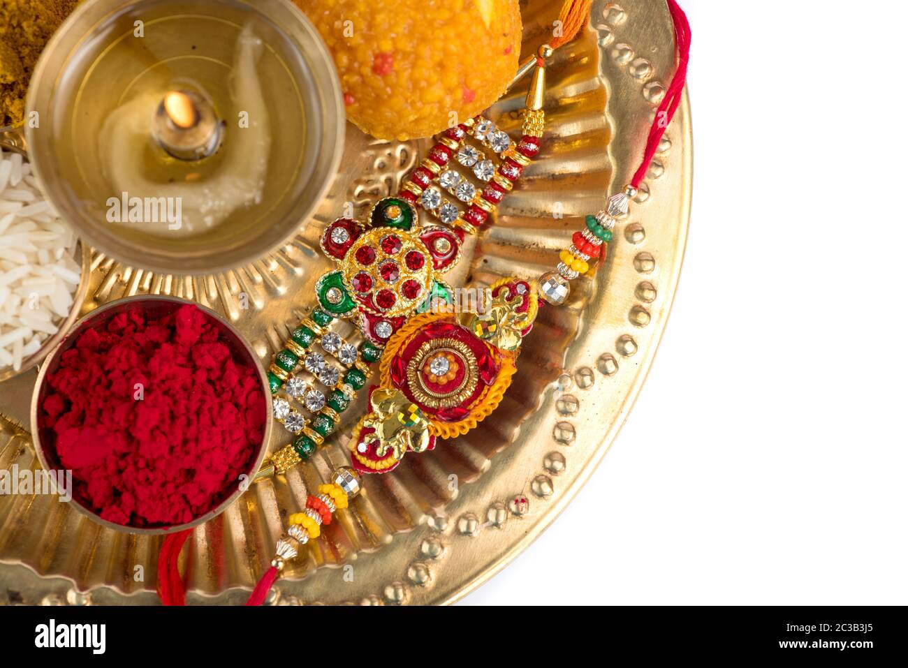 Indian Festival: Rakhi with rice grains, kumkum, sweets and diya on ...