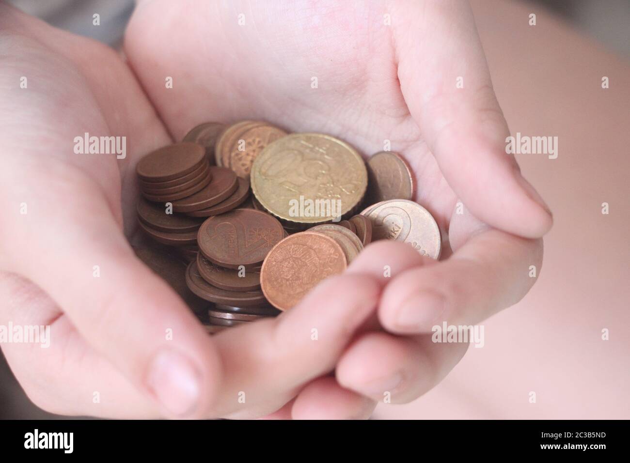 Two hands full of coins. Concept of savings or kid's pocket money Stock ...