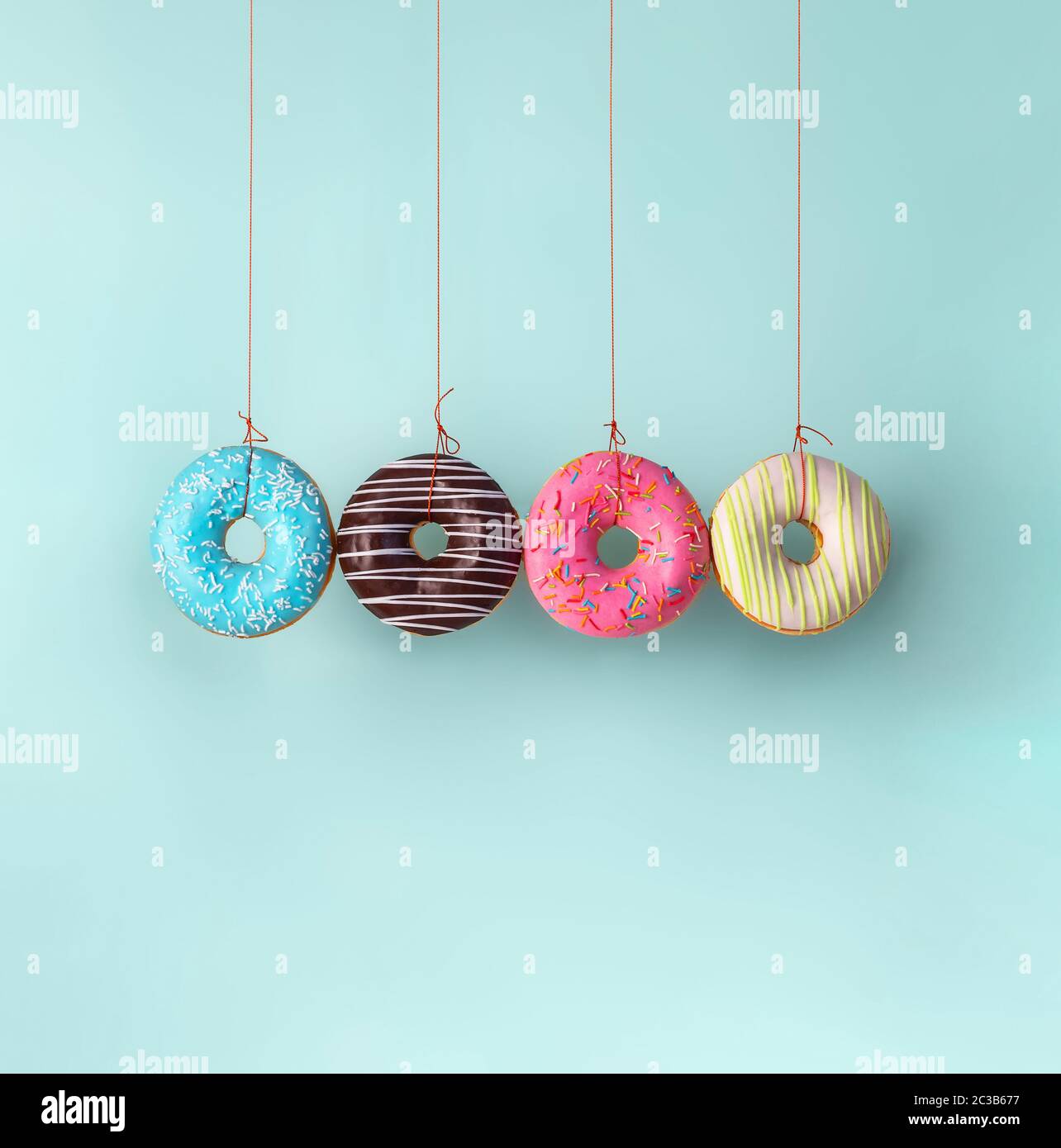 Four donuts hanging on the ropes. Harm of sugar, donuts time or healthy ...
