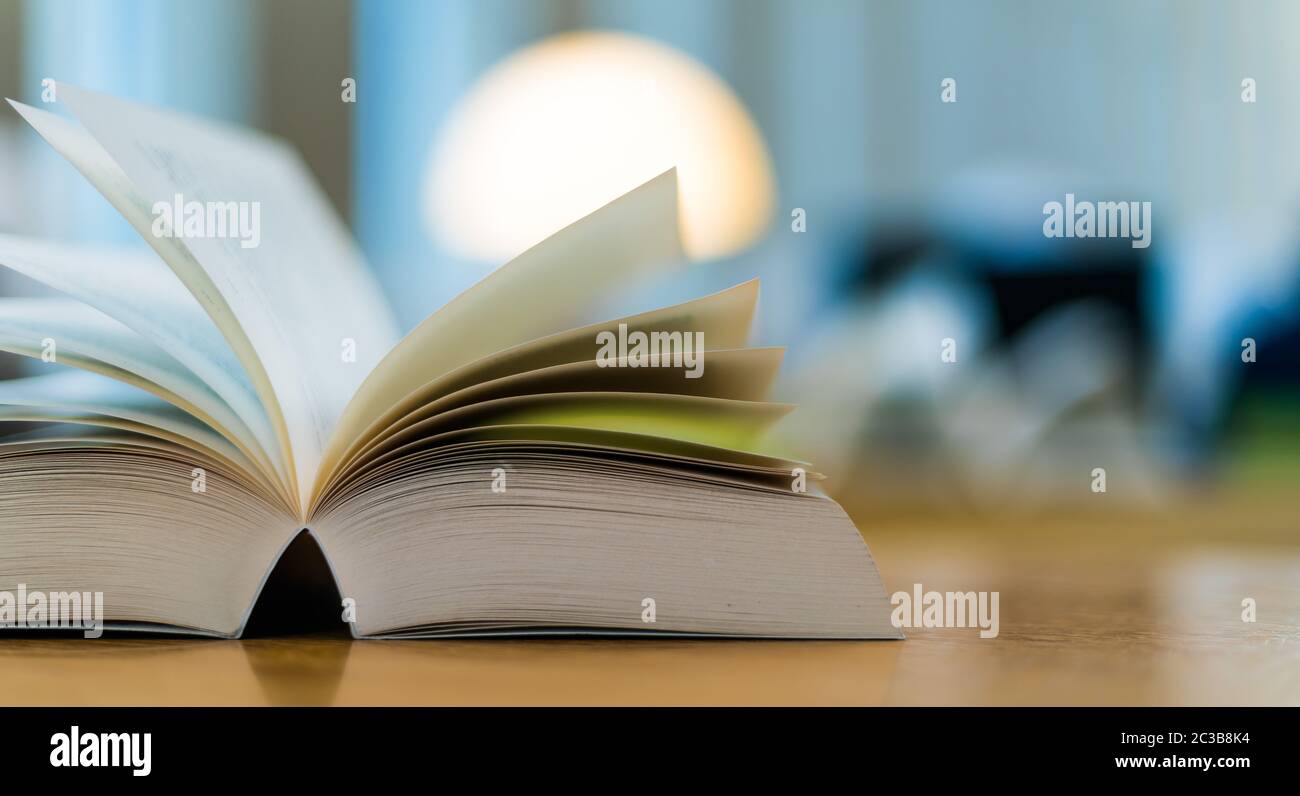 Open book lying on the table in the public library Stock Photo - Alamy