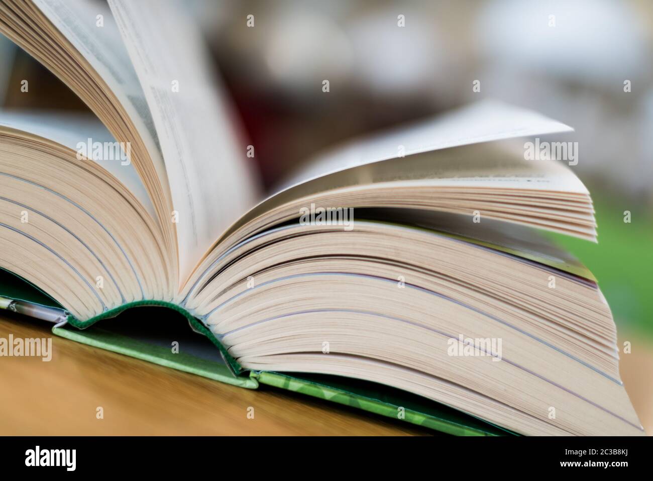 Open book lying on the table in the public library Stock Photo - Alamy