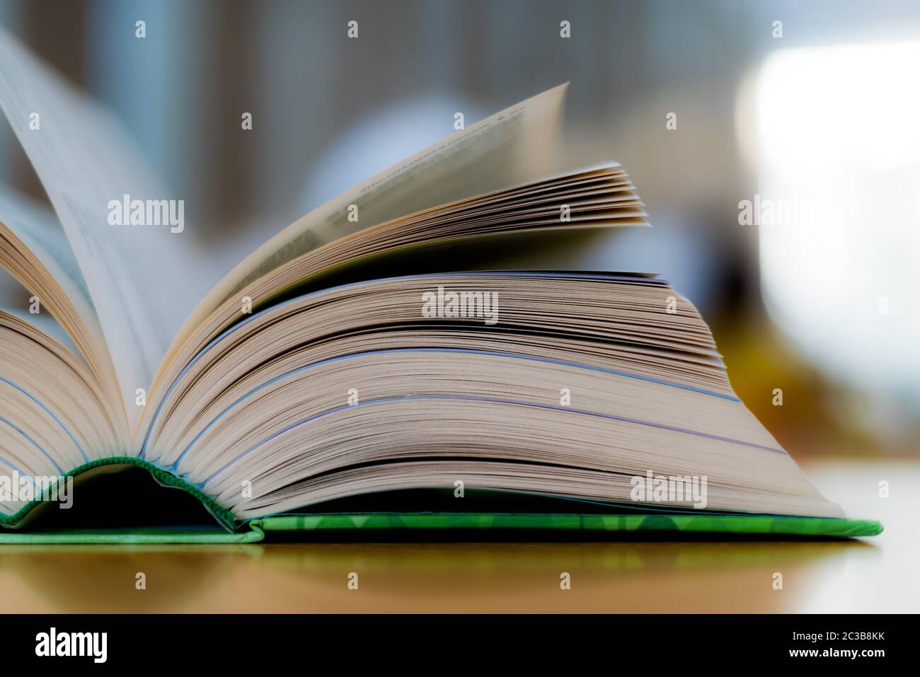 Open book lying on the table in the public library Stock Photo - Alamy