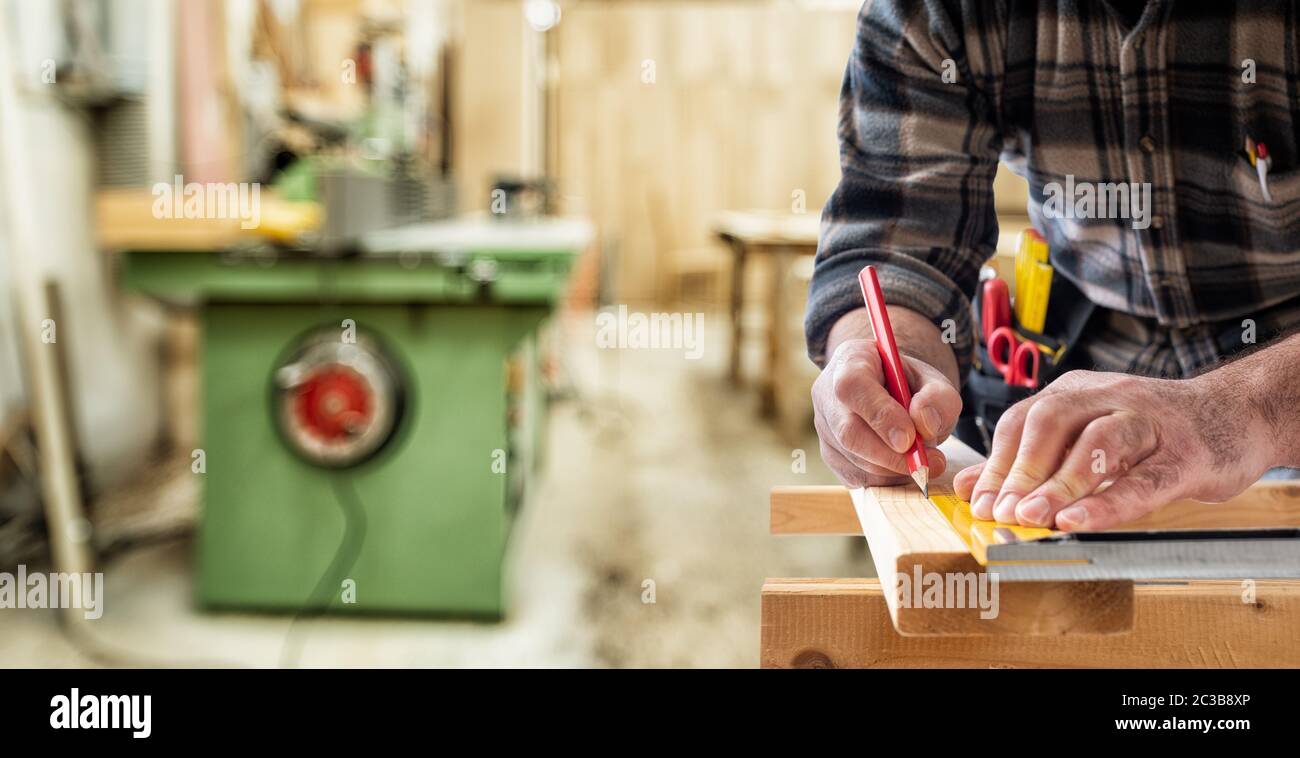 Close-up. Carpenter with pencil and carpenter's square draw the cutting ...