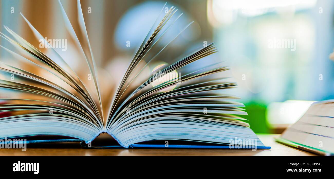 Open book lying on the table in the public library Stock Photo - Alamy