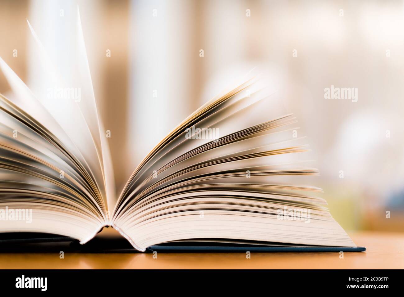 Open book lying on the table in the public library Stock Photo - Alamy