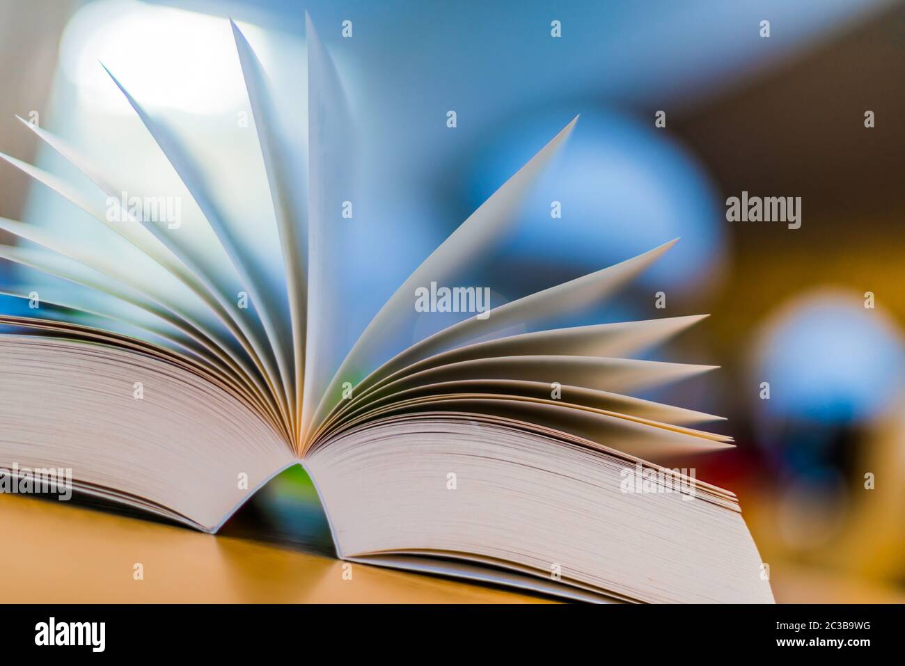 Open book lying on the table in the public library Stock Photo - Alamy