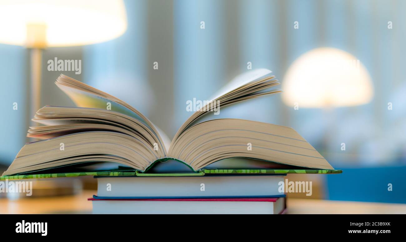 Open book lying on the table in the public library Stock Photo - Alamy