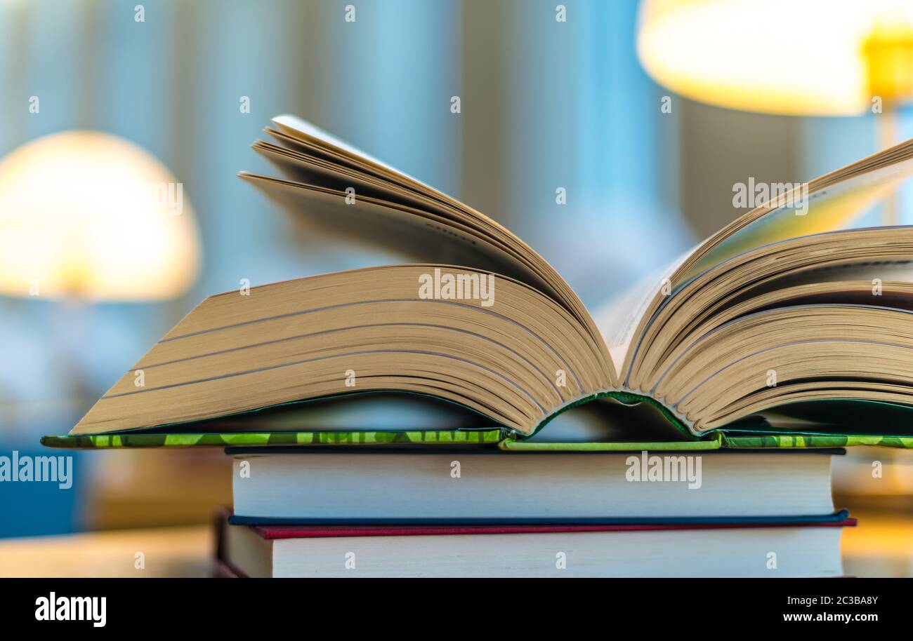 Open book lying on the table in the public library Stock Photo - Alamy