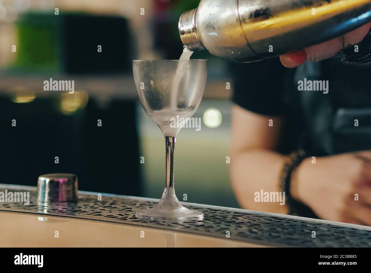 a Bartender pouring cocktail at bar counter Stock Photo - Alamy