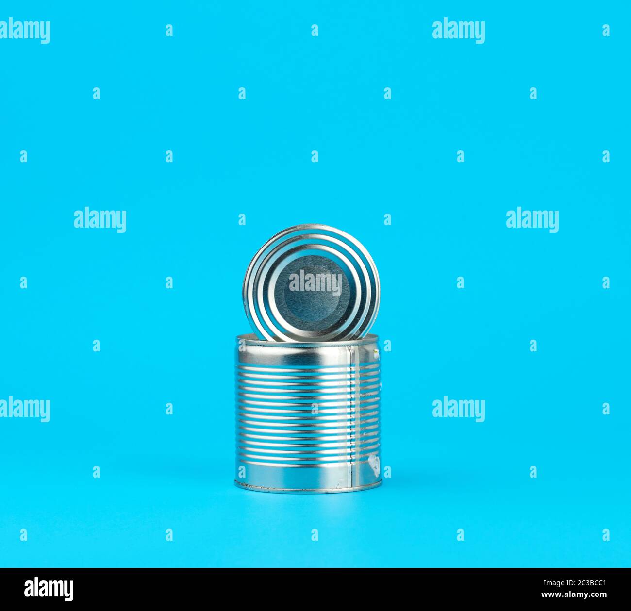 open hard iron can for food preservation on a blue background, copy ...