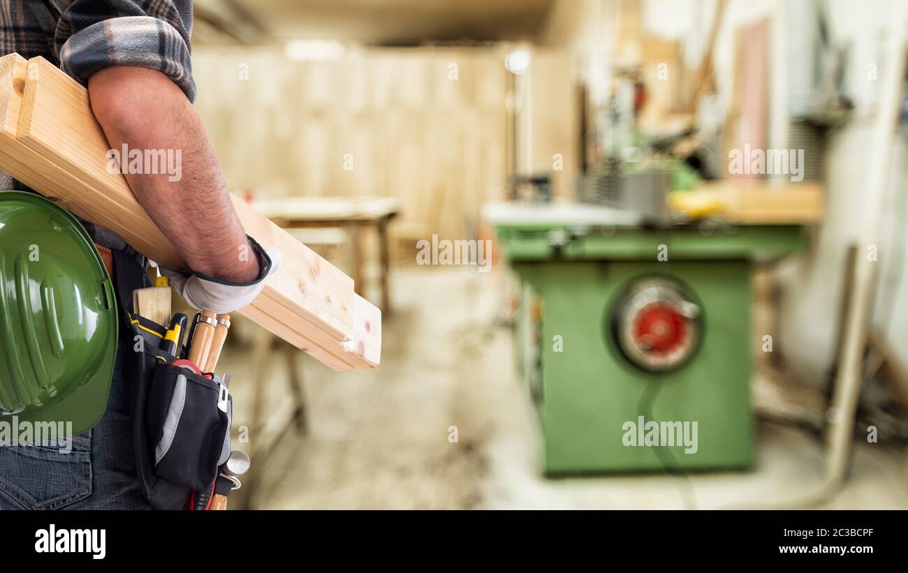 Close-up. Carpenter with his hands protected by gloves carries the ...