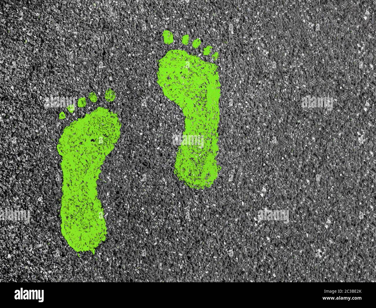 Green footprint signs on an asphalt road for pedestrian. Symbol of ...