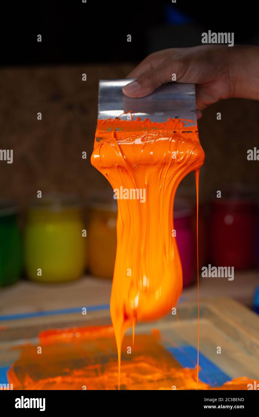 orange color dripping from hand screen printing during printing tee ...