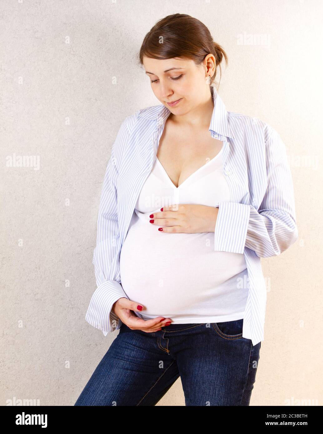 Pregnant woman touching belly gently Stock Photo - Alamy