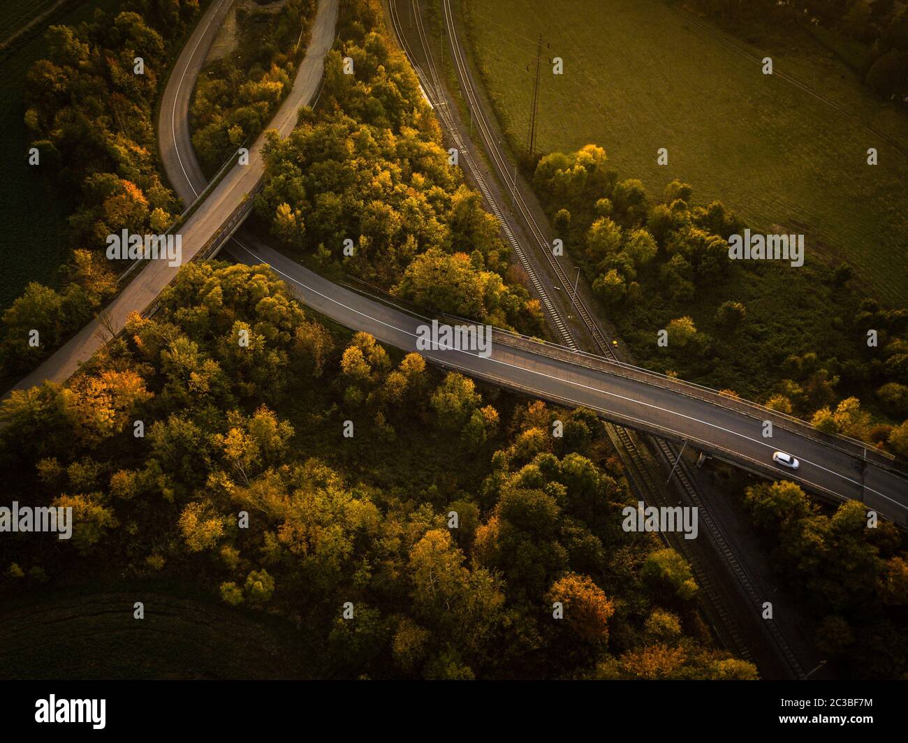 Winding road in autumn forest at sunset in mountains. Aerial view. Top ...