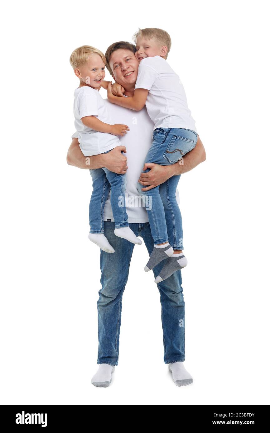 Friendly family. Young man holding two children stands isolated on a ...