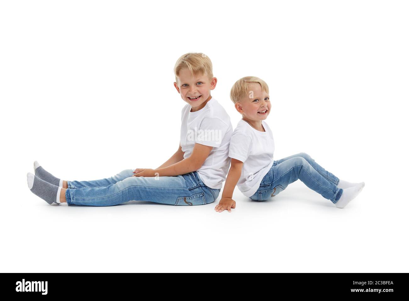 Friendly family. Older brother and younger boy are sitting with backs ...