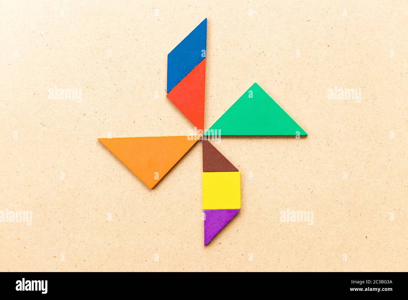 Color tangram puzzle in turbine, wheel or windmill shape on wood ...