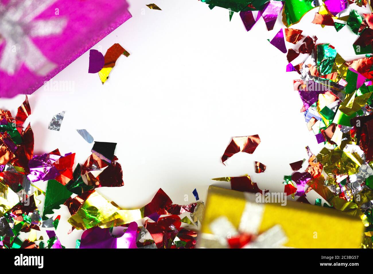 Multi-colored confetti and colorful presents isolated on white ...