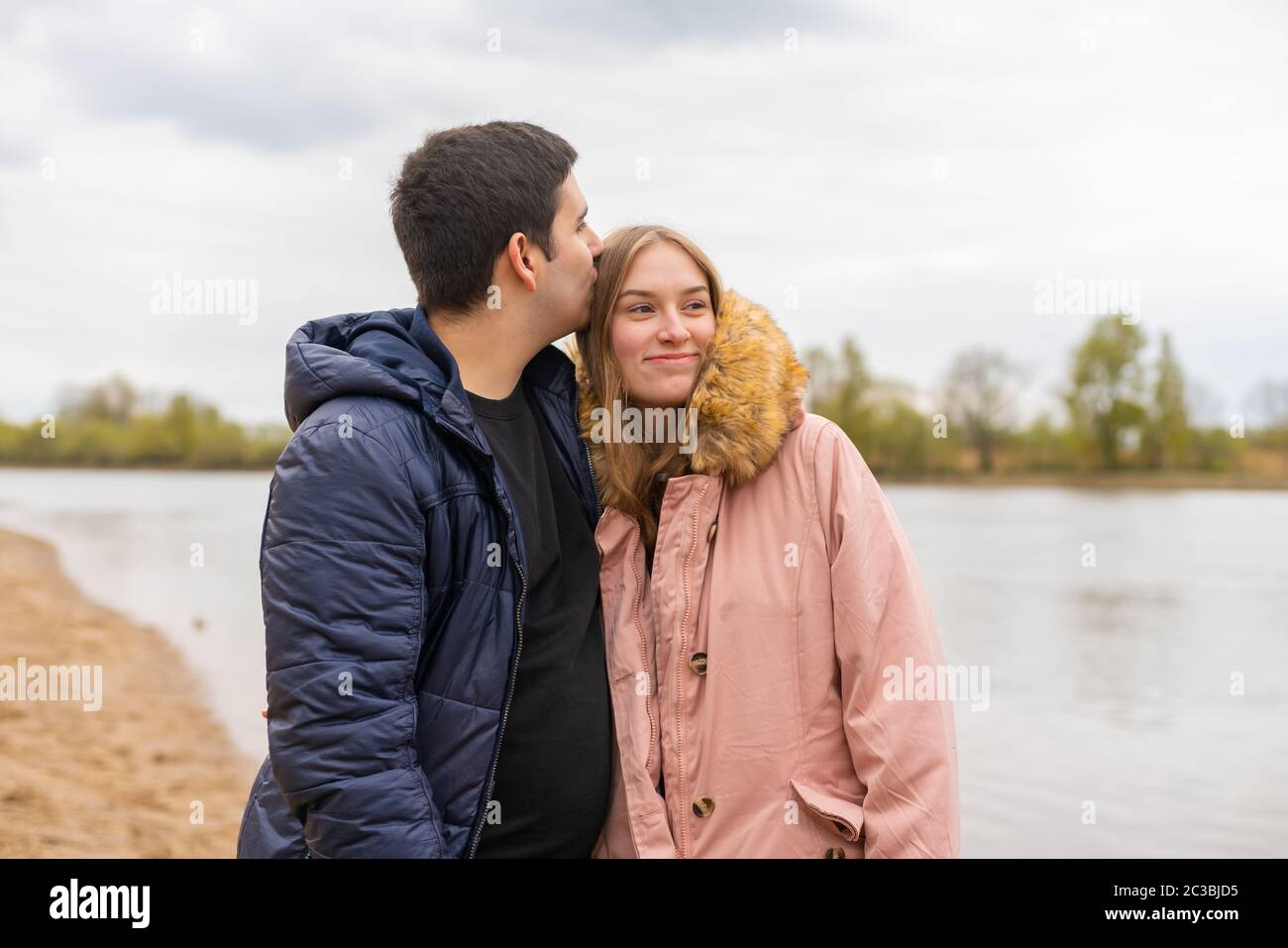 a young couple stands contentedly on a beach Stock Photo - Alamy