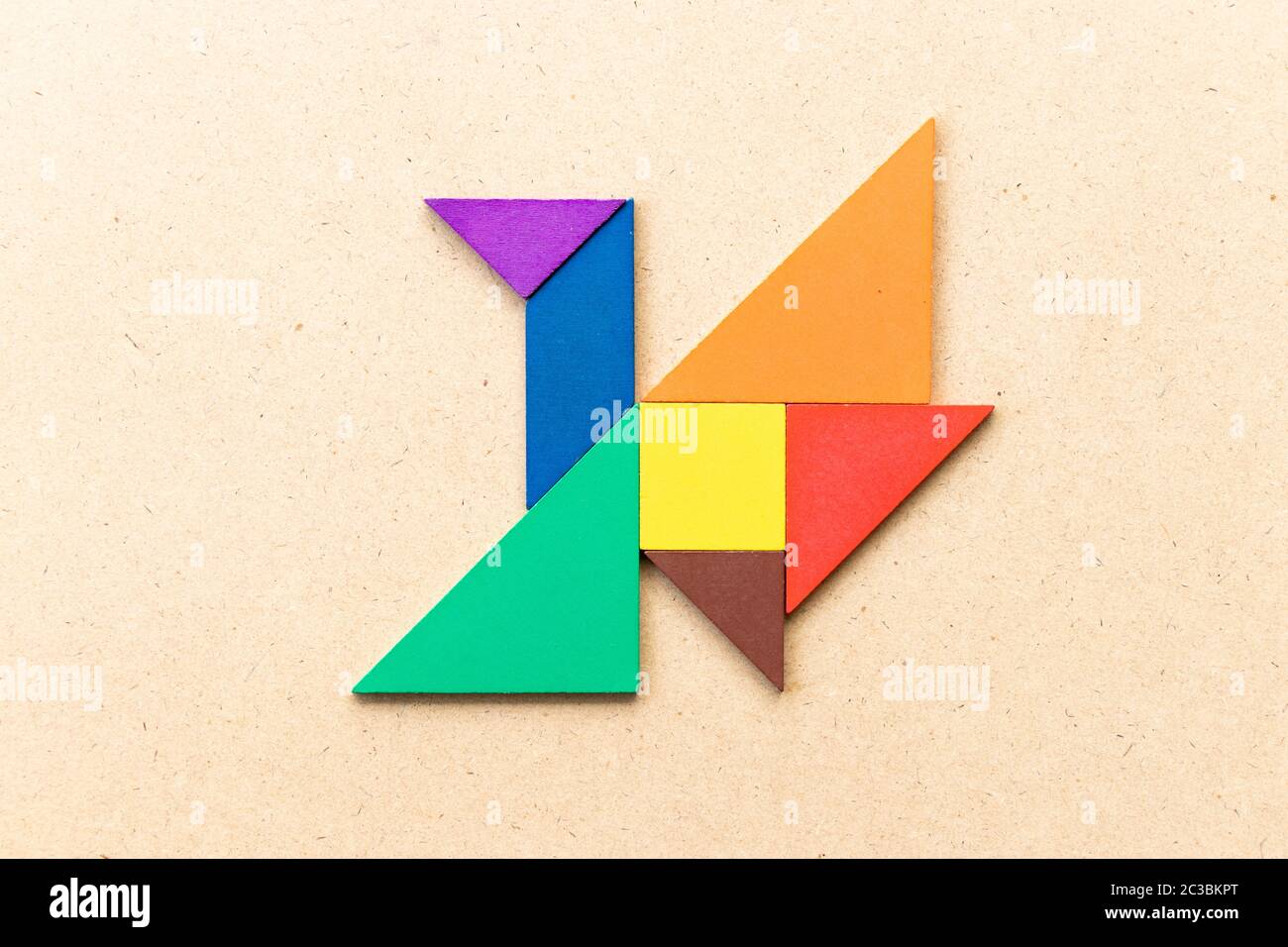 Color tangram puzzle in flying bird shape on wood background Stock ...