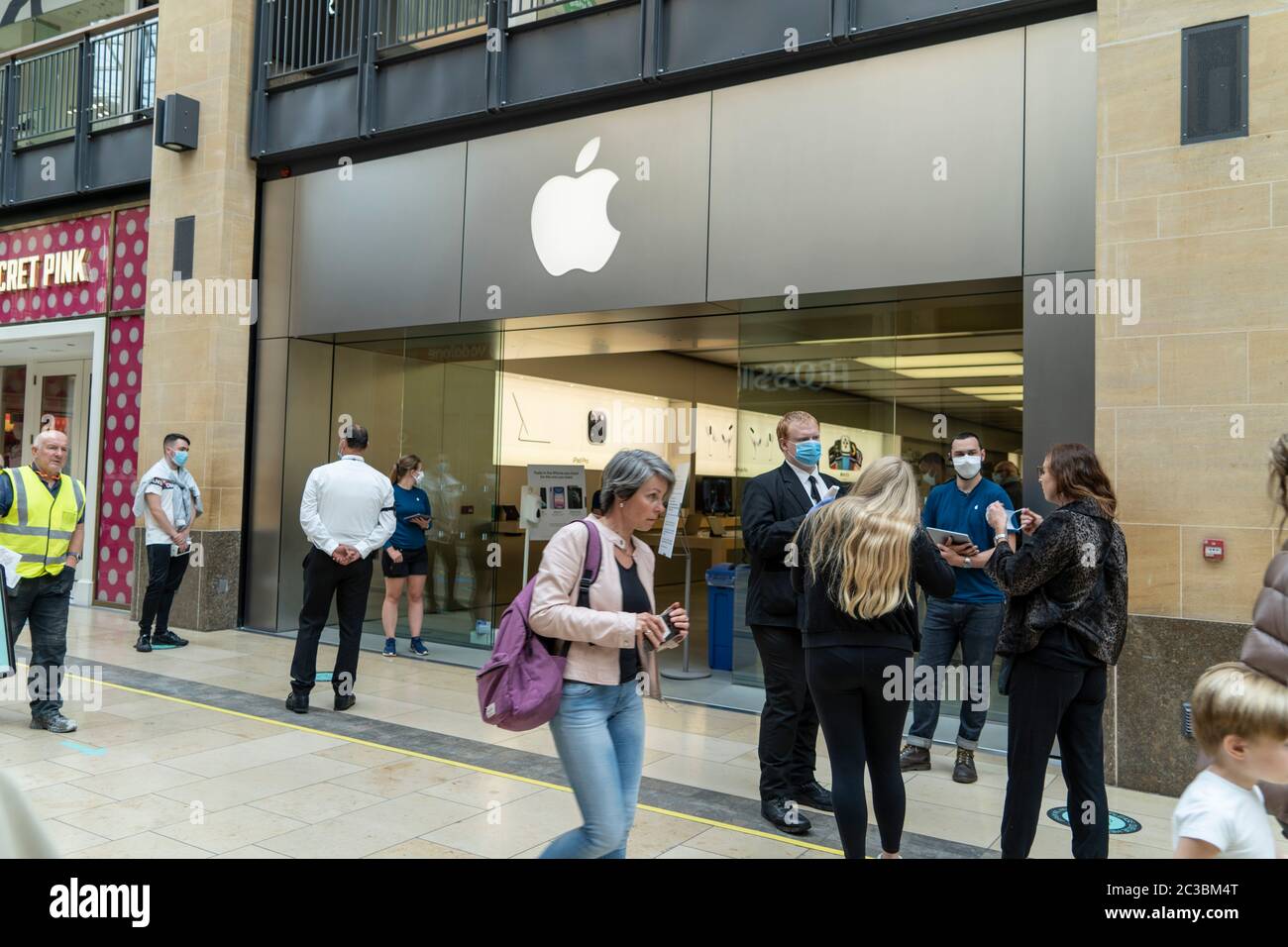People wear face masks outside the front of the Apple store in ...
