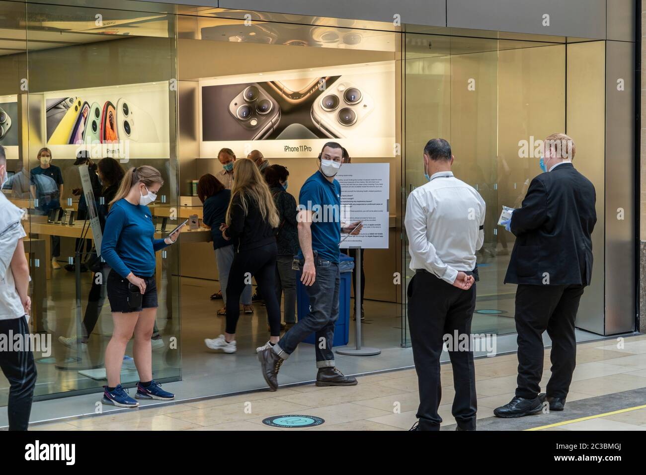People wear face masks outside the front of the Apple store in ...