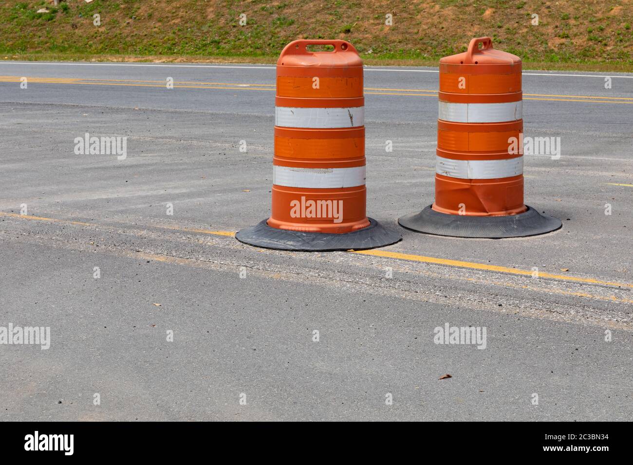 Two traffic safety barrels on an asphalt street, road construction ...