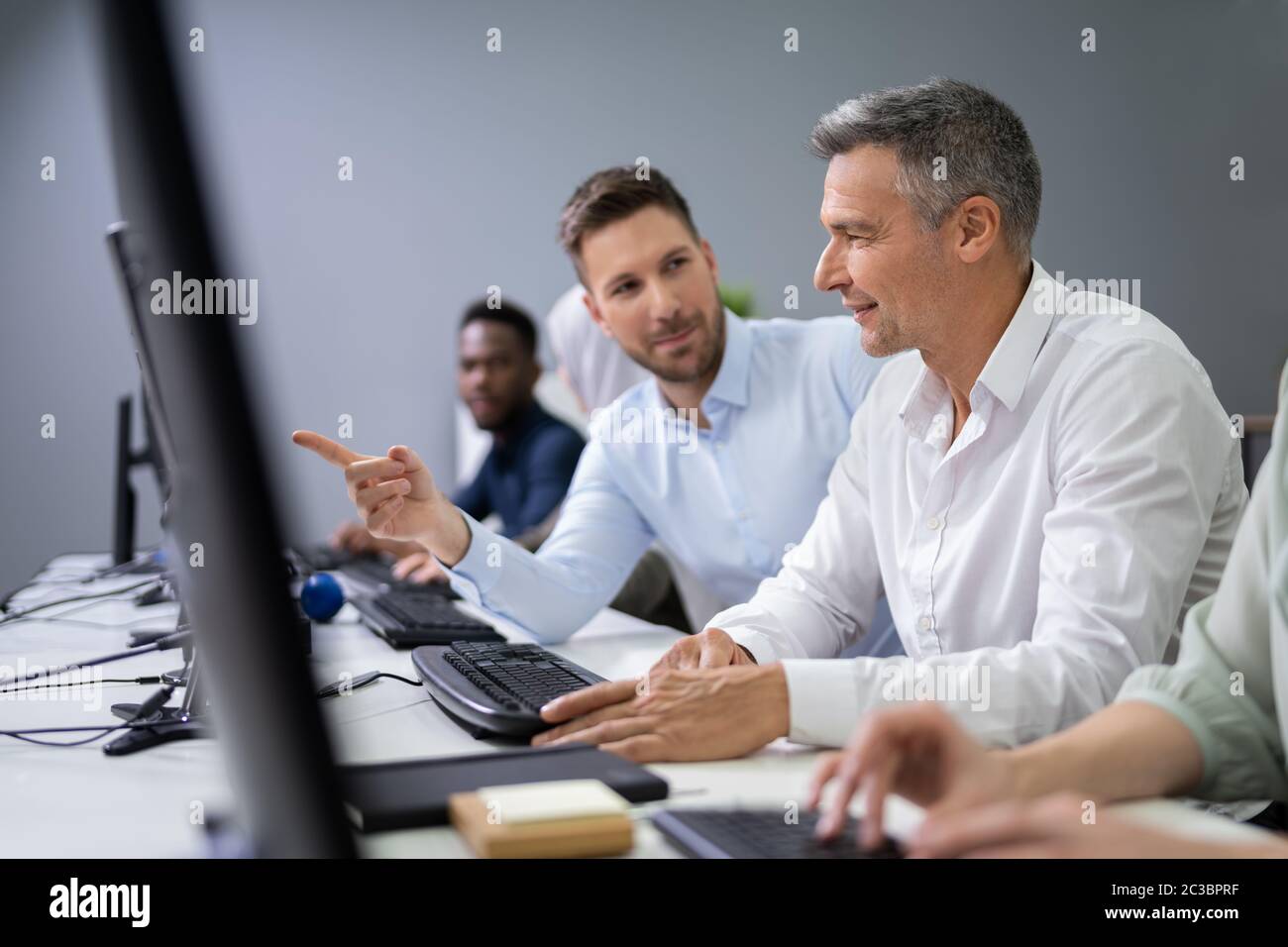 Young Businessman Helping His Colleagues In The Work Of Office Stock ...