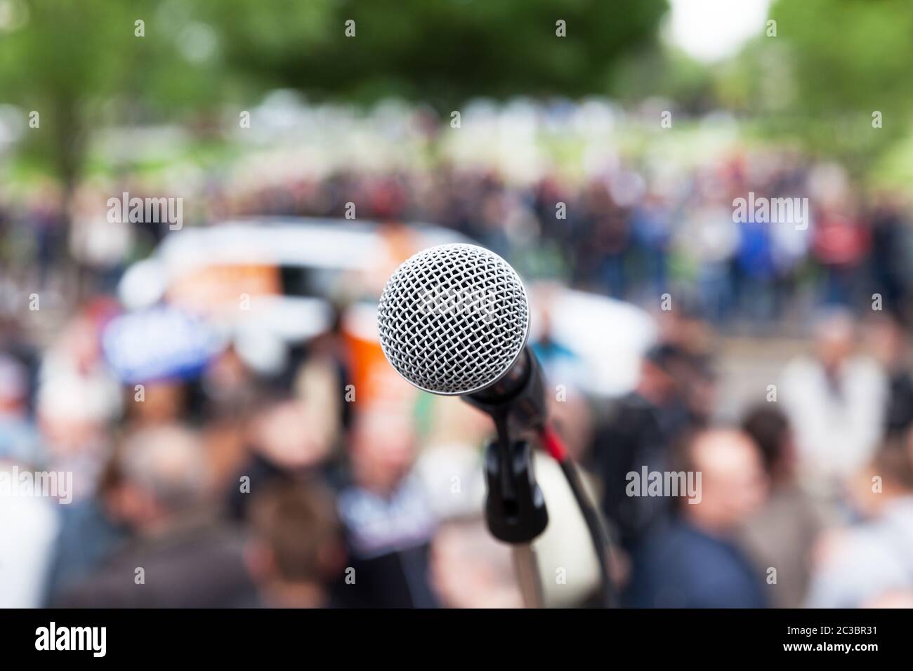 Microphone in focus against blurred crowd Stock Photo - Alamy