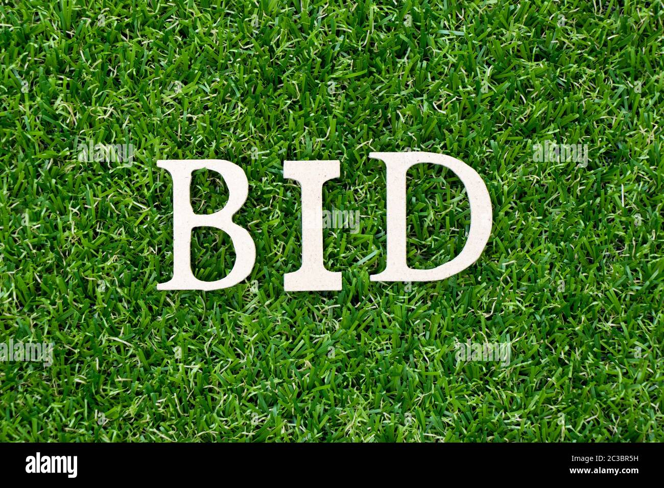 Wood letter in word bid on green grass background Stock Photo - Alamy