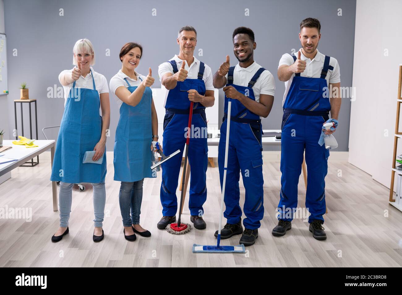 Portrait Of Happy Diverse Janitors In The Office With Cleaning ...