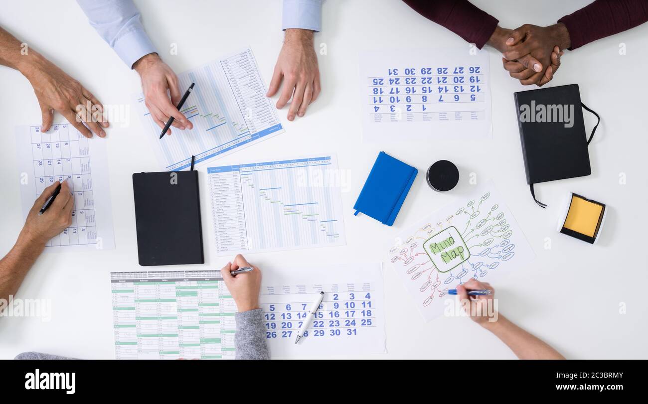 Group Of People Planning Project Using Gantt Charts And Calendars Stock ...