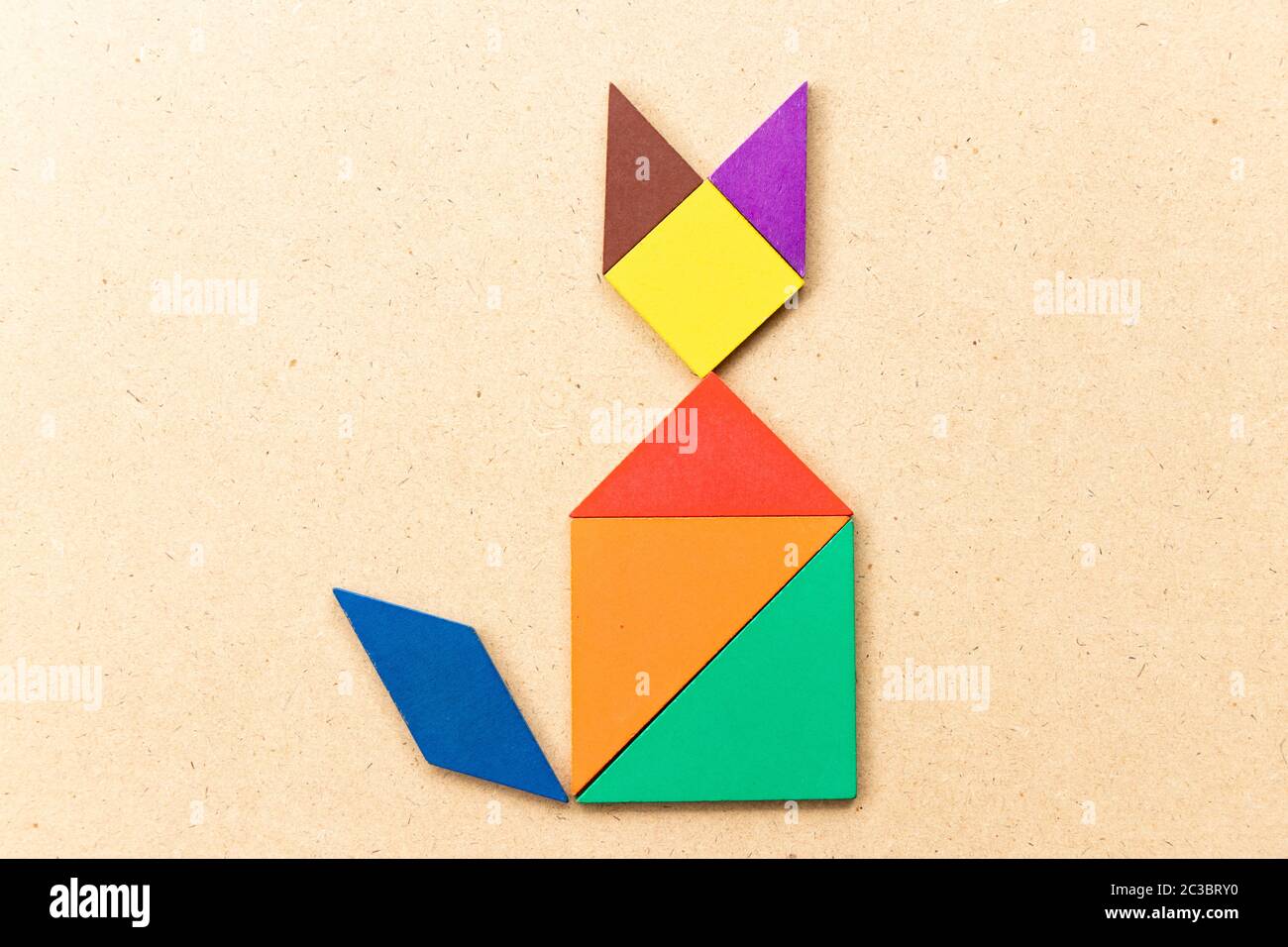 Color tangram puzzle in sitting cat shape on wood background Stock ...