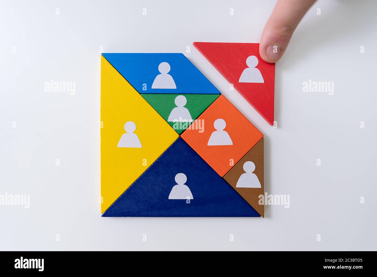 Businessman's Hand Building Tangram Square Block With Human Figures ...