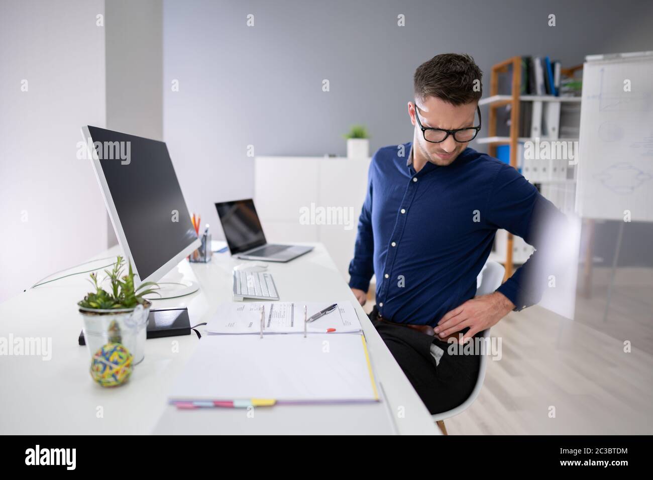 Businessman Suffering From Back Pain While Working On Laptop Stock ...