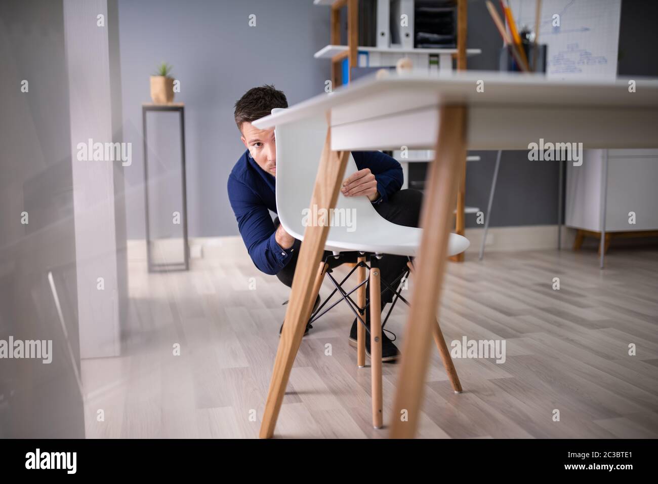 Hiding behind chair hi-res stock photography and images - Alamy