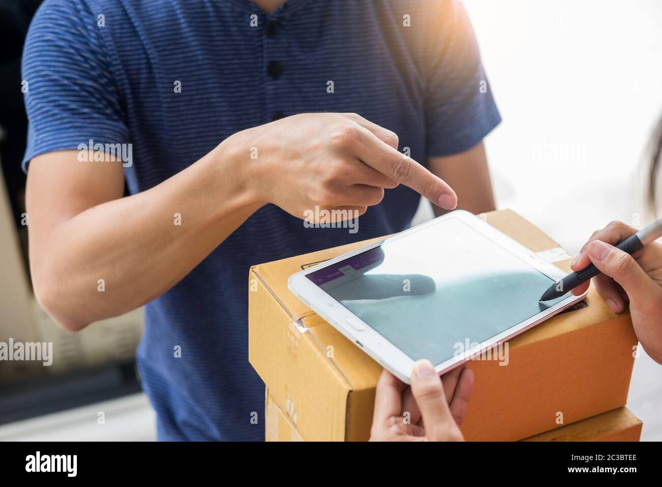 woman courier holding a parcel Shipping Mail appending signature ...