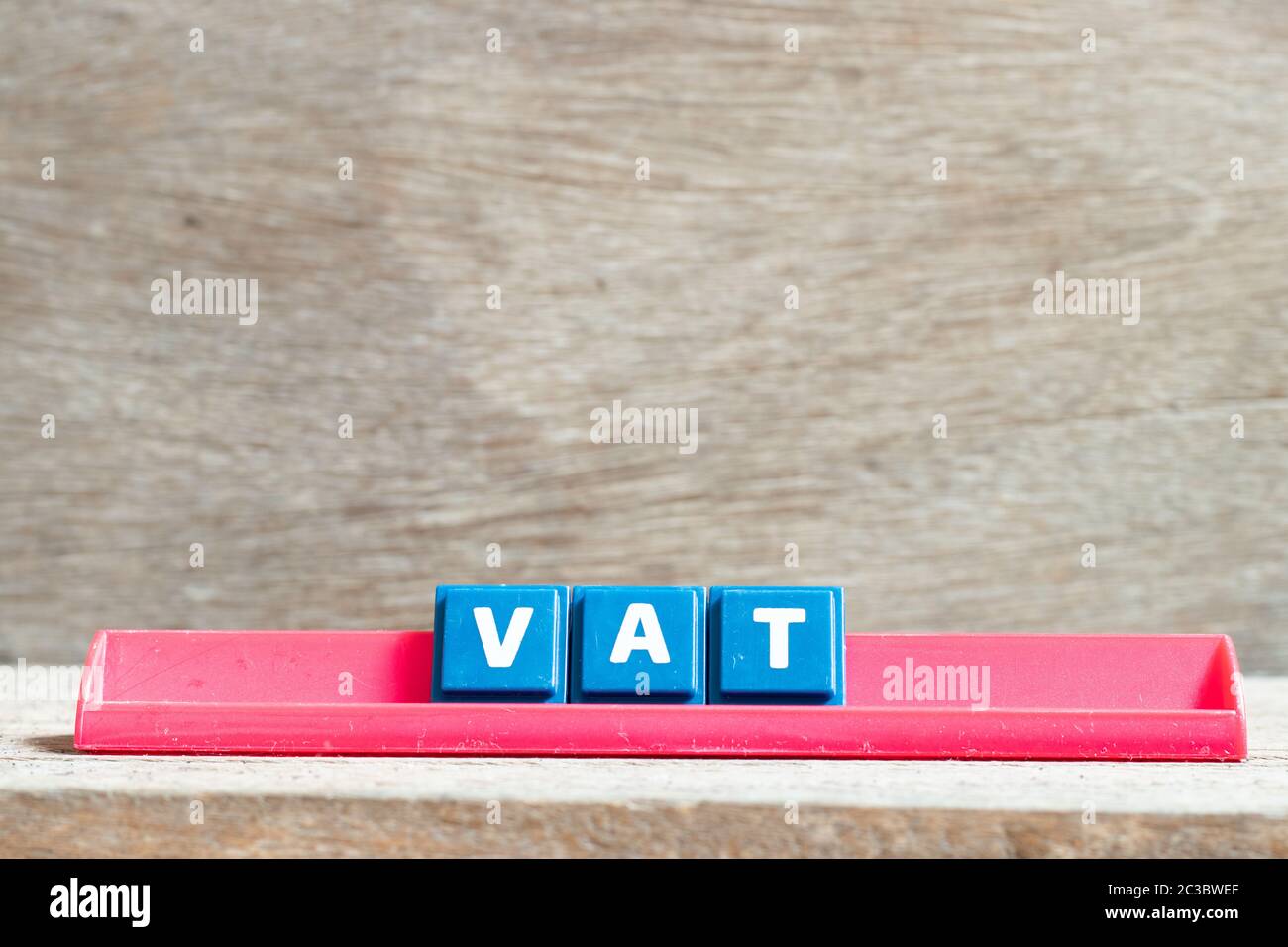 Tile letter on red rack in word vat (abbreviation of value added tax ...