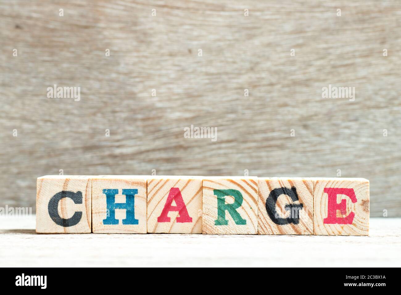 Alphabet letter block in word charge on wood background Stock Photo - Alamy