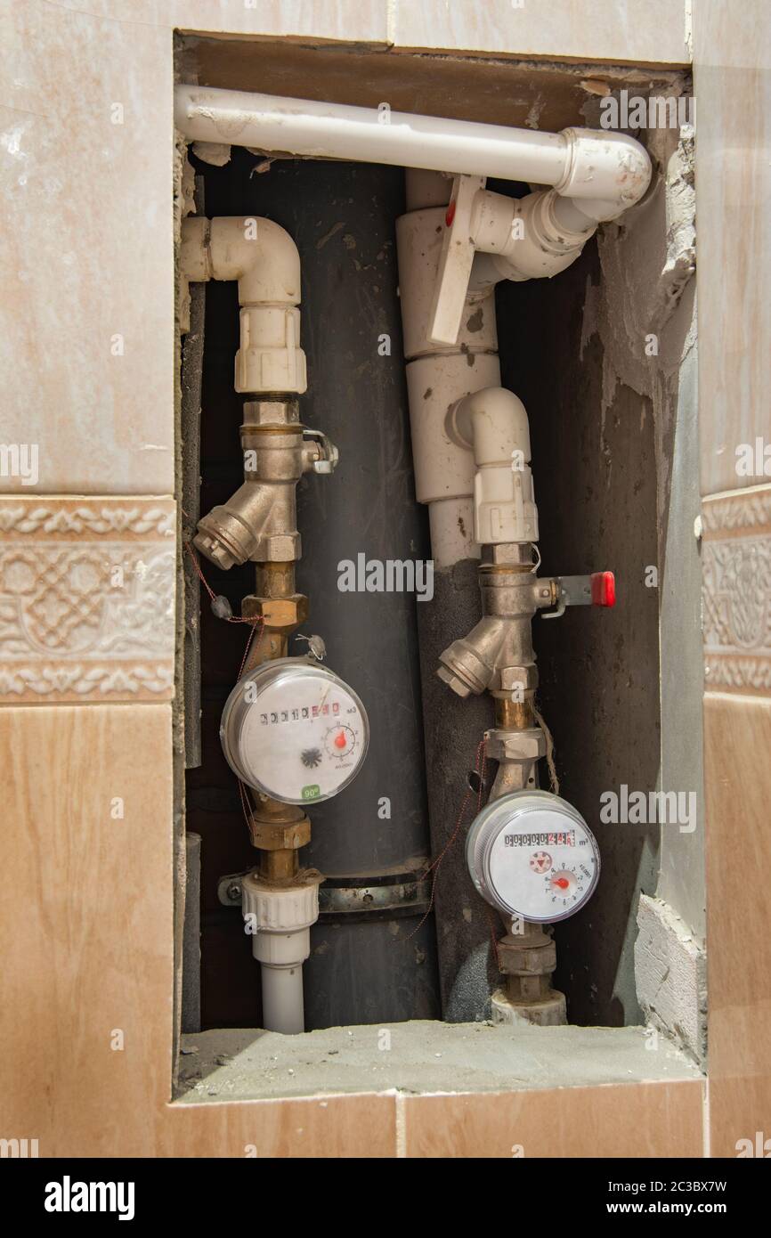 cold and hot water meters embedded in the wall Stock Photo - Alamy